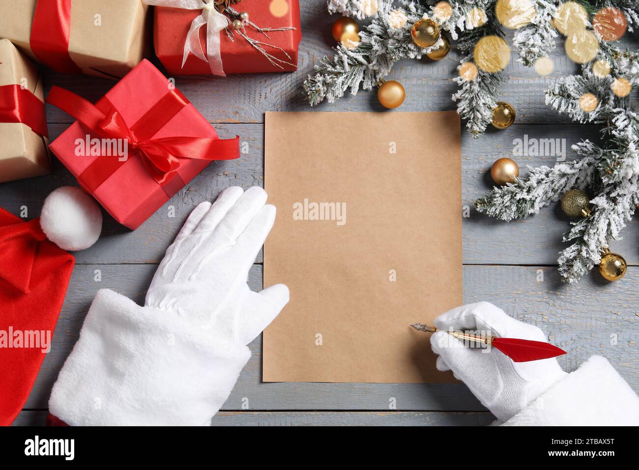Santa Claus writing letter with fountain pen at grey wooden table, top ...