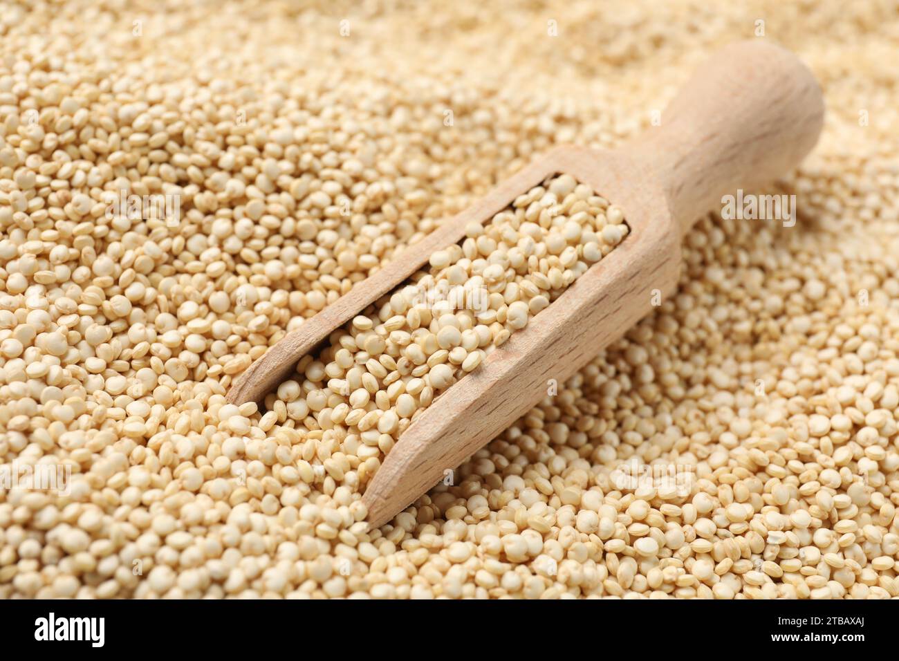Wooden scoop and raw quinoa as background, closeup Stock Photo - Alamy