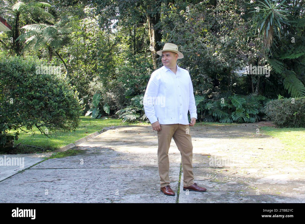 A 40-year-old dark-skinned Latin man very elegantly wears a guayabera ...