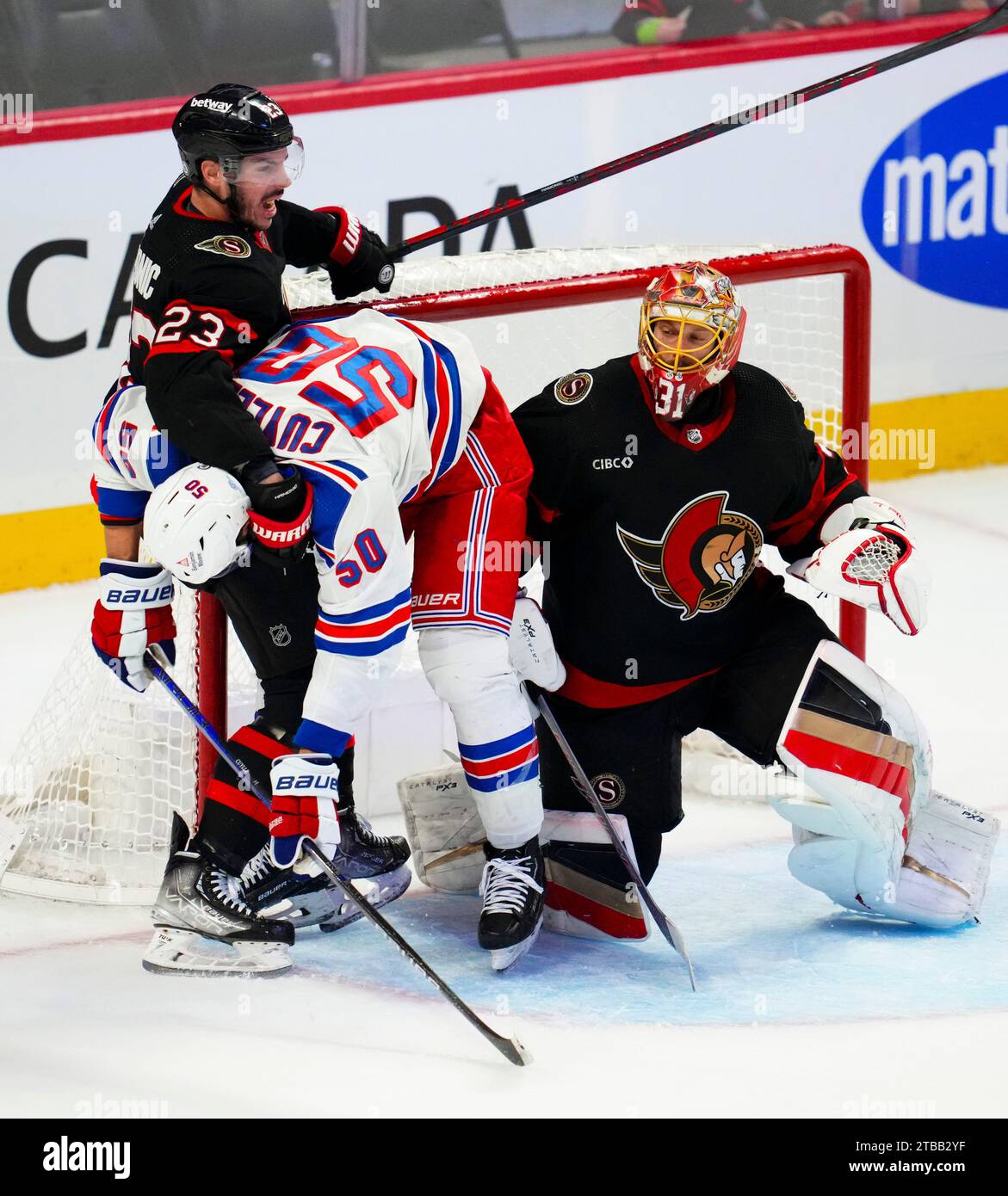 Ottawa Senators defenceman Travis Hamonic (23) becomes entagled with ...