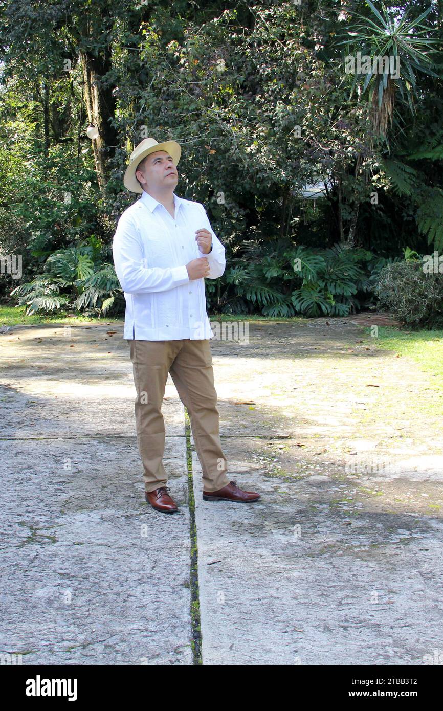 A 40-year-old dark-skinned Latin man very elegantly wears a guayabera ...