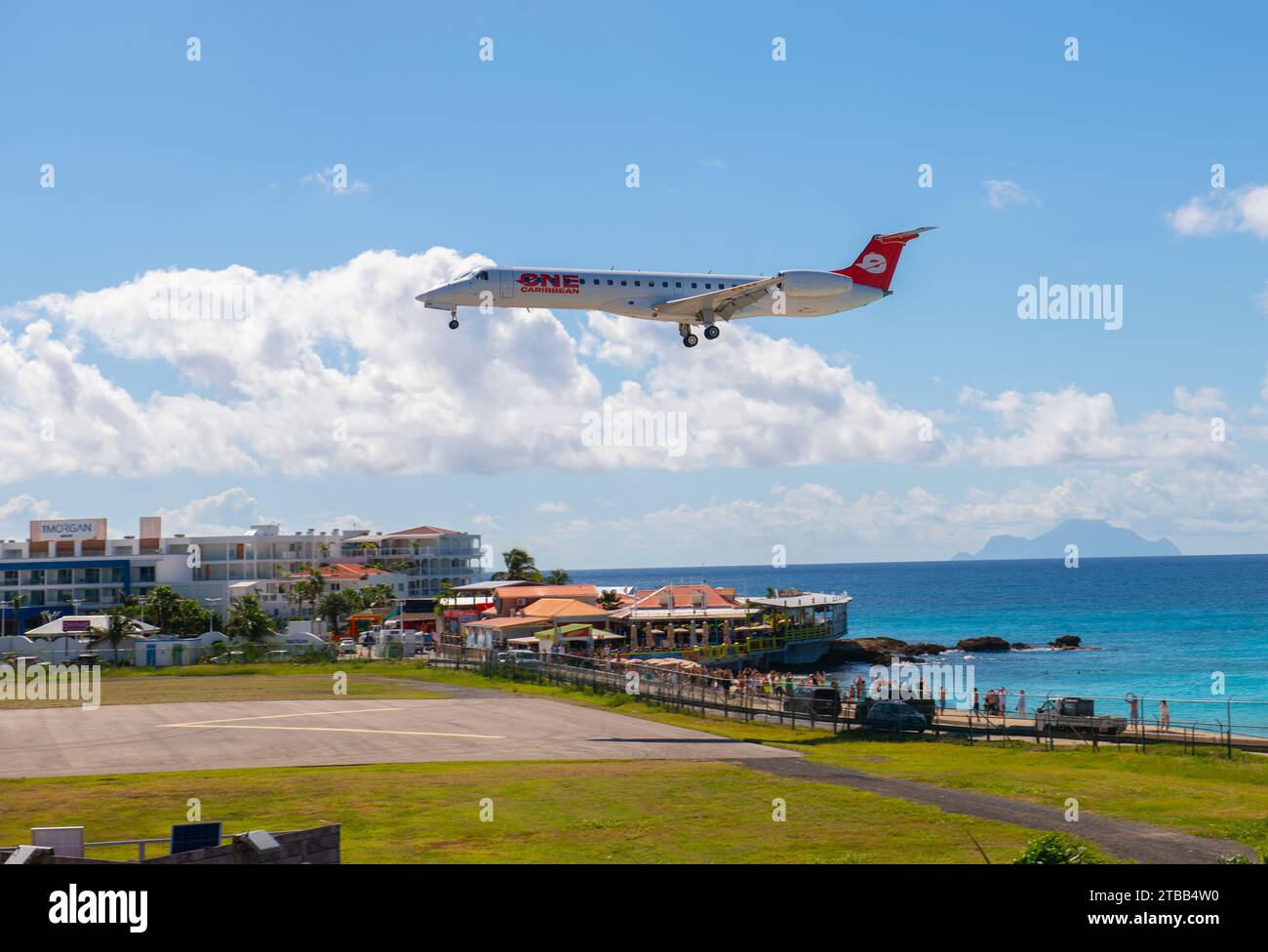 One Caribbean Sunrise Airways Embraer ERJ-145LR flying over Maho Beach ...