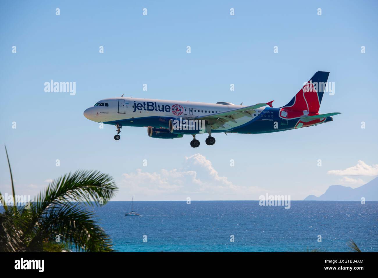 JetBlue Airways Airbus 320 flying over Maho Beach before landing on ...