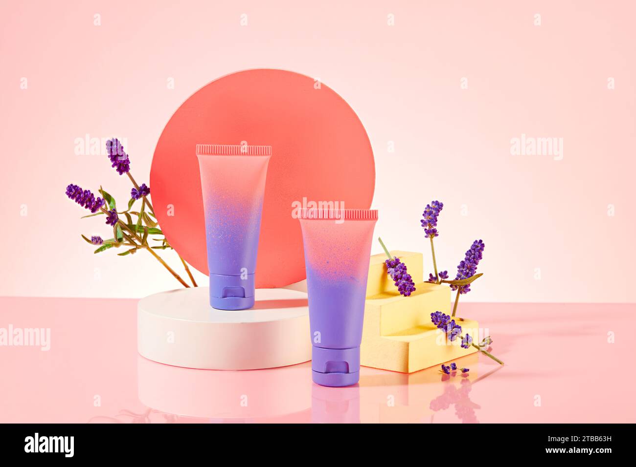 Two tubes of sunscreen embossed on a pastel pink background with ...