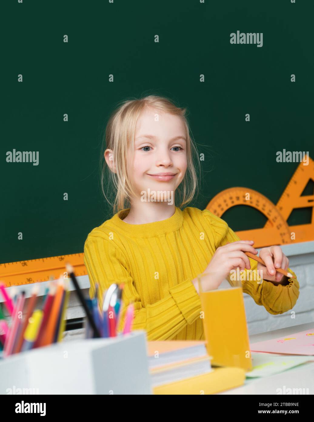 Cute little school kid girl study in a classroom. Genius child ...