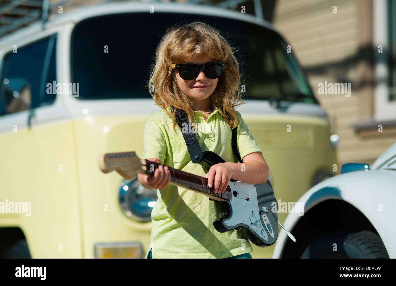 Child musician playing the guitar like a rockstar outdoor. Kid boy rock ...