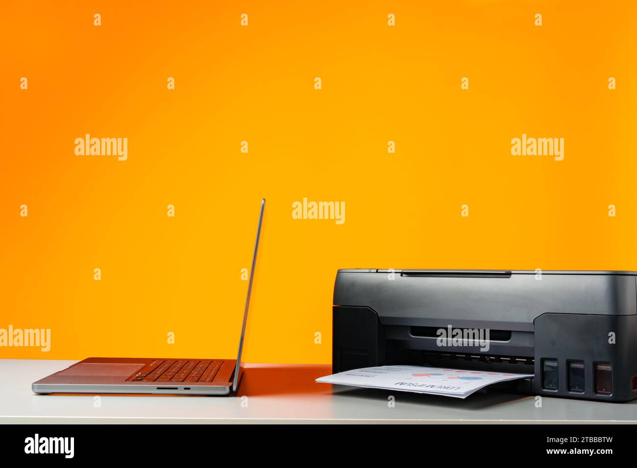 Laser printer on desk against yellow background Stock Photo - Alamy