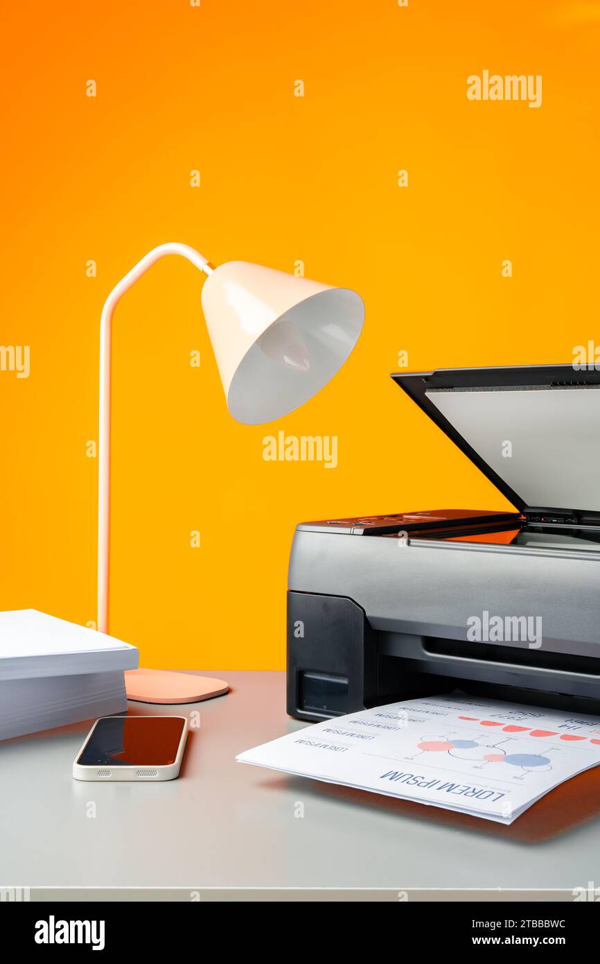 Laser printer on desk against yellow background Stock Photo - Alamy