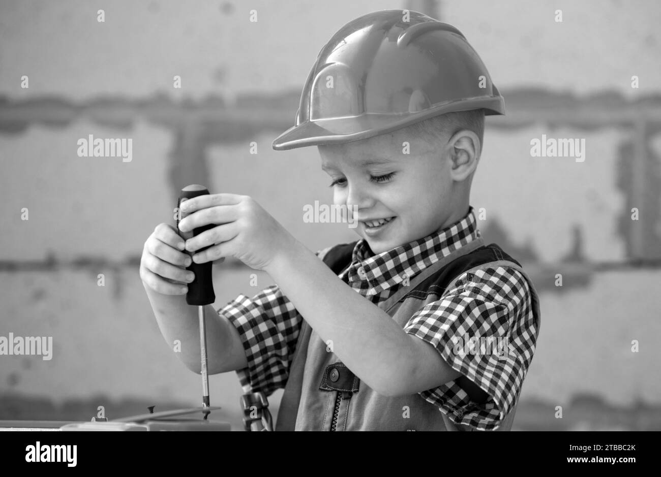Little boy holding screwdriver. Kid twists bolt with screwdriver ...