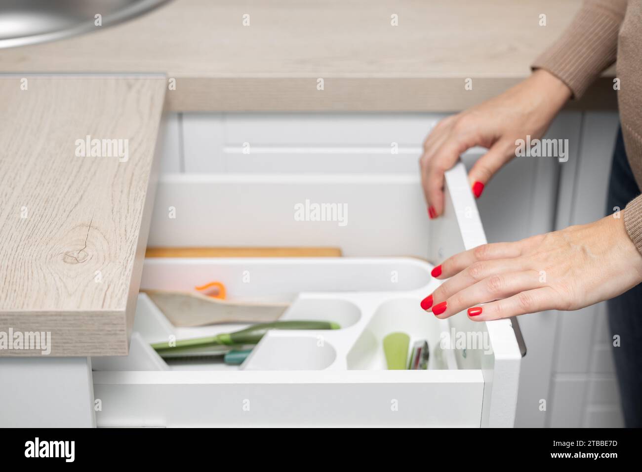 woman's hand opens a kitchen drawer with cutlery. female hand opens ...