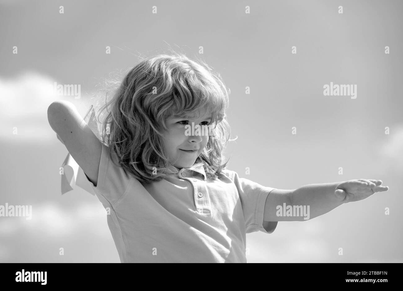 Kid dreaming and plays with a toy plane in the park. Dreams of travel ...