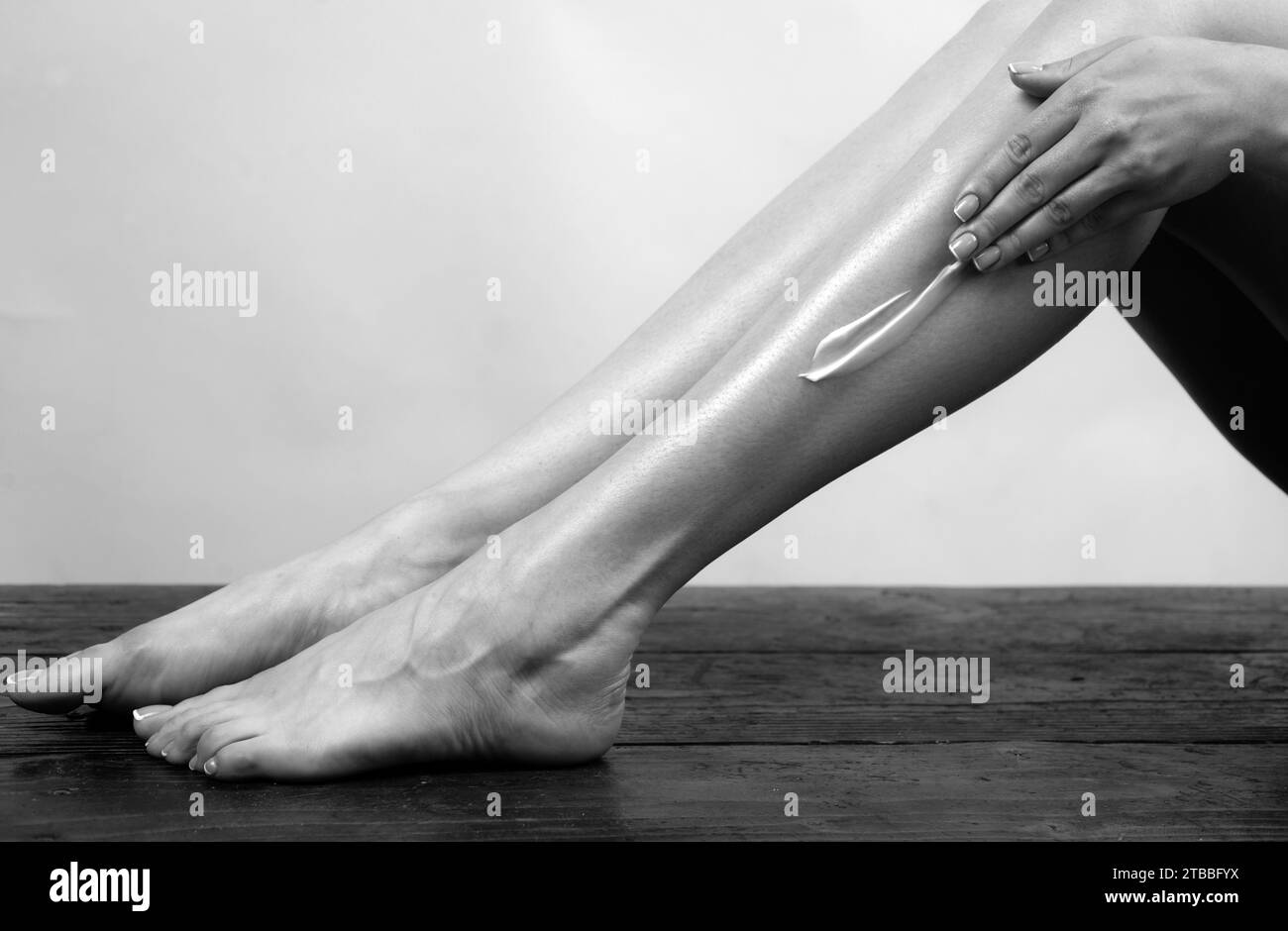 Woman applying moisturiser legs Black and White Stock Photos & Images ...
