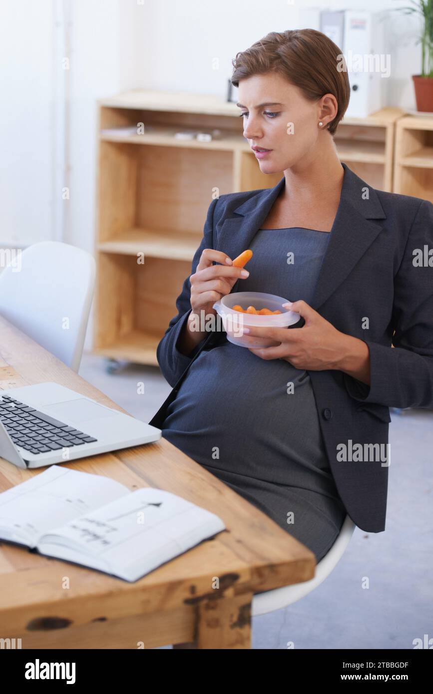 Business woman, pregnant and eating carrots for healthy diet, nutrition ...
