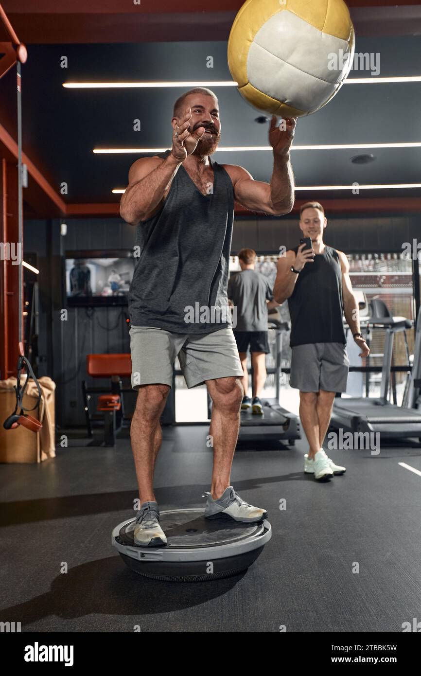 The guy tries to keep his balance on the balancing platform with ...