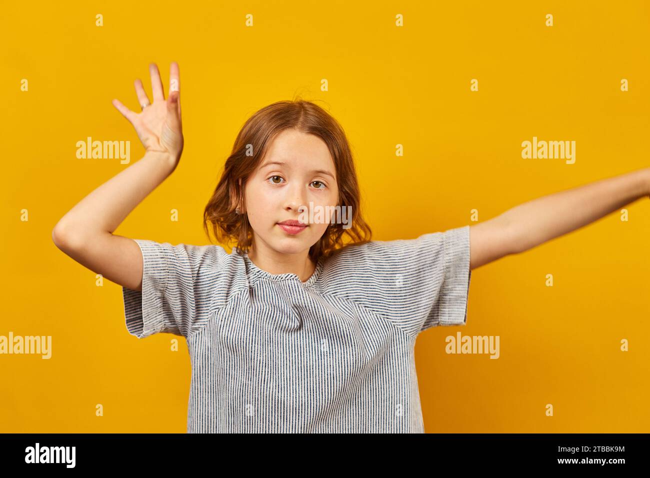 Happy teen girl dancing on yellow studio background Stock Photo - Alamy