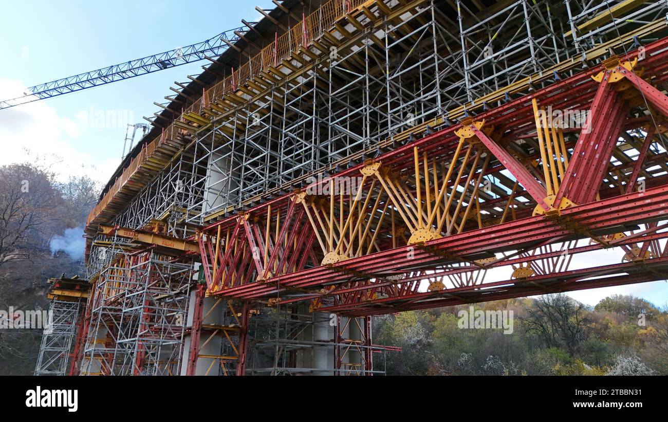 An aerial view of a bridge in the process of construction, with cranes ...