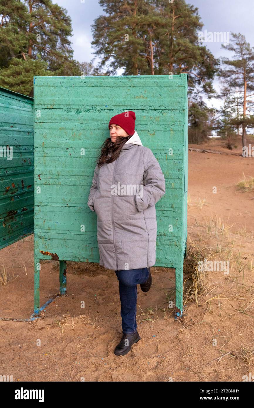 A fashionable woman in chic autumn attire strikes a pose next to a ...