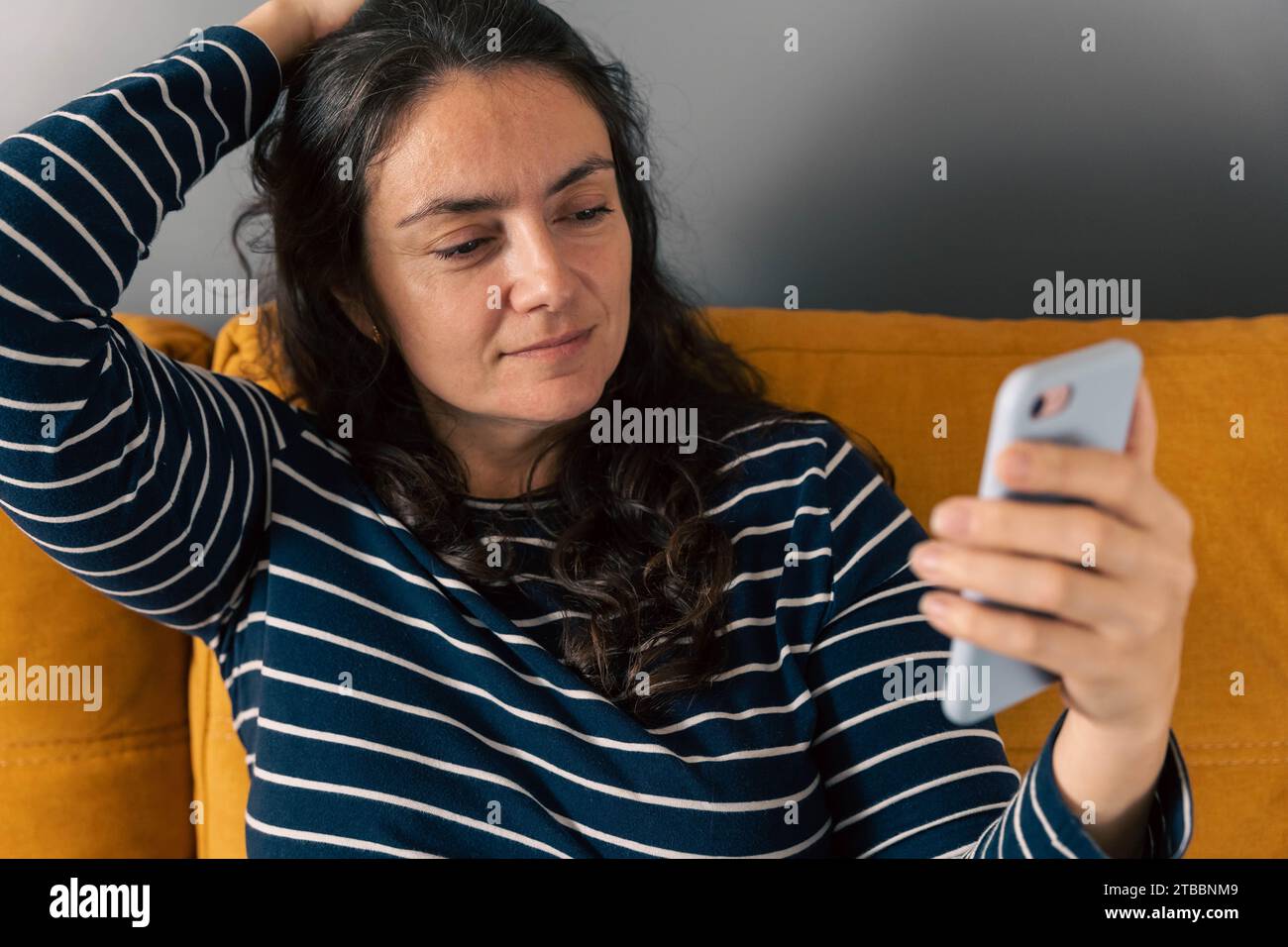 A cheerful middle-aged woman with a satisfied expression sitting on a ...