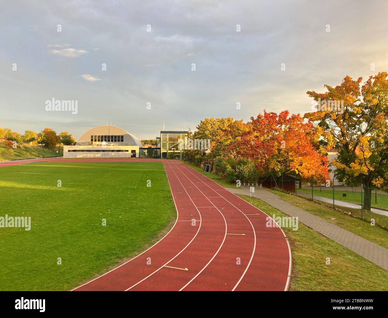 Oval Running Track A Lone Athlete Runs In The Outer Lane Of An Outdoor