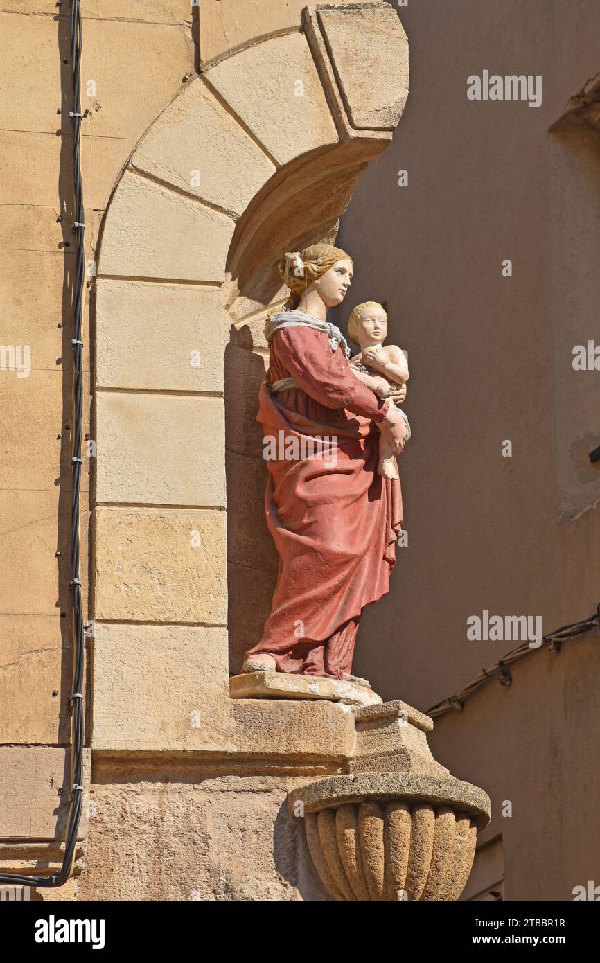 Virgin and child, in a niche, she unusually dressed in red, and child ...