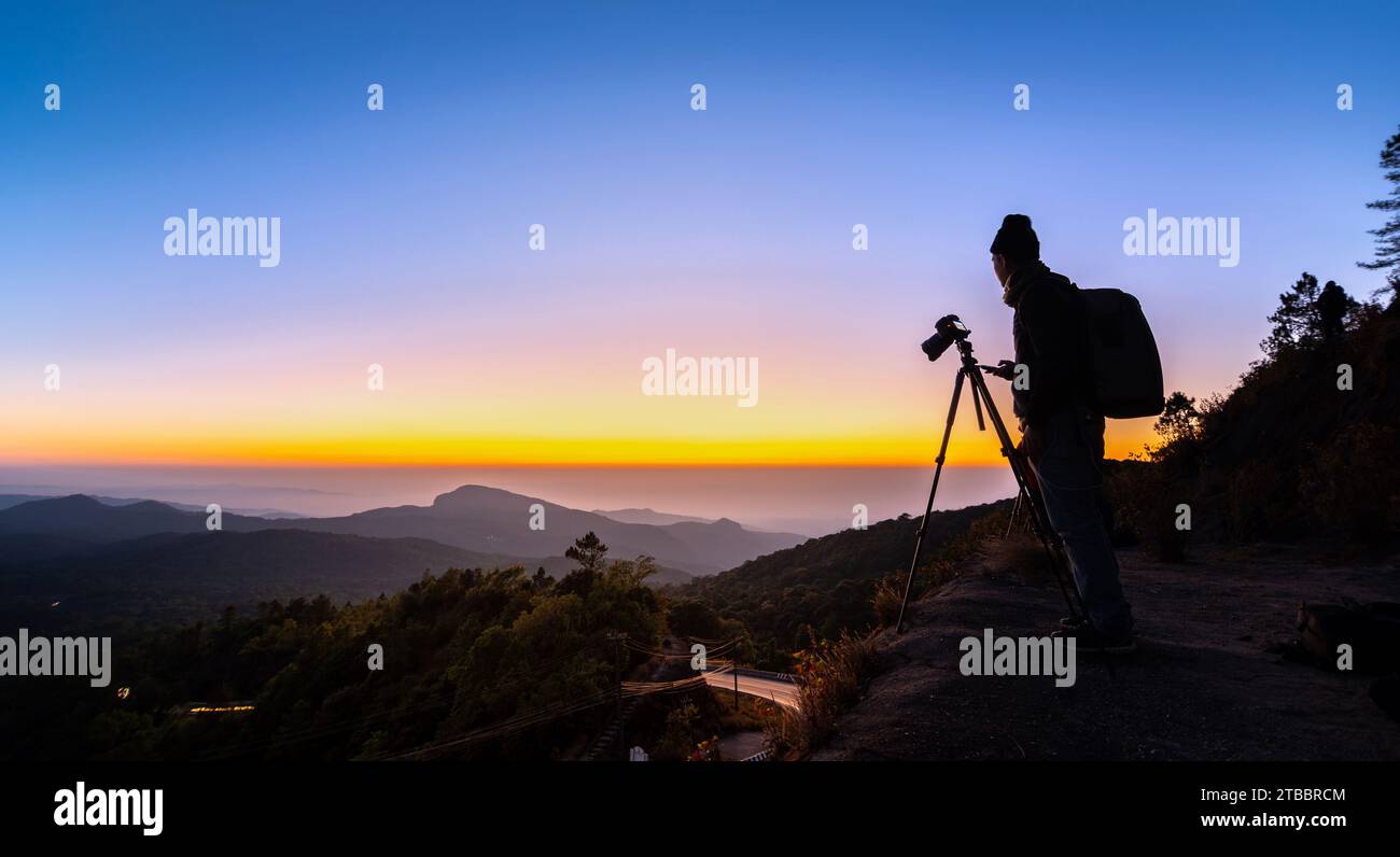 Silhouette Professional Photographer with camera take a landscape photo ...