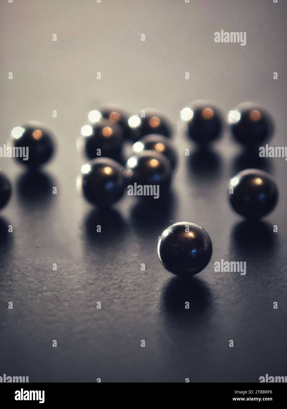 A cluster of spherical objects resting on a flat surface, arranged side ...