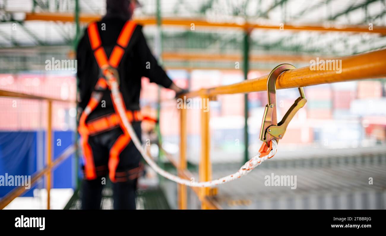Construction worker wearing safety harness and safety line working at high place Stock Photo - Alamy
