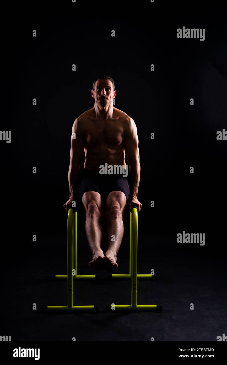 Male gymnast performing handstand on parallel bars, studio shot Stock ...