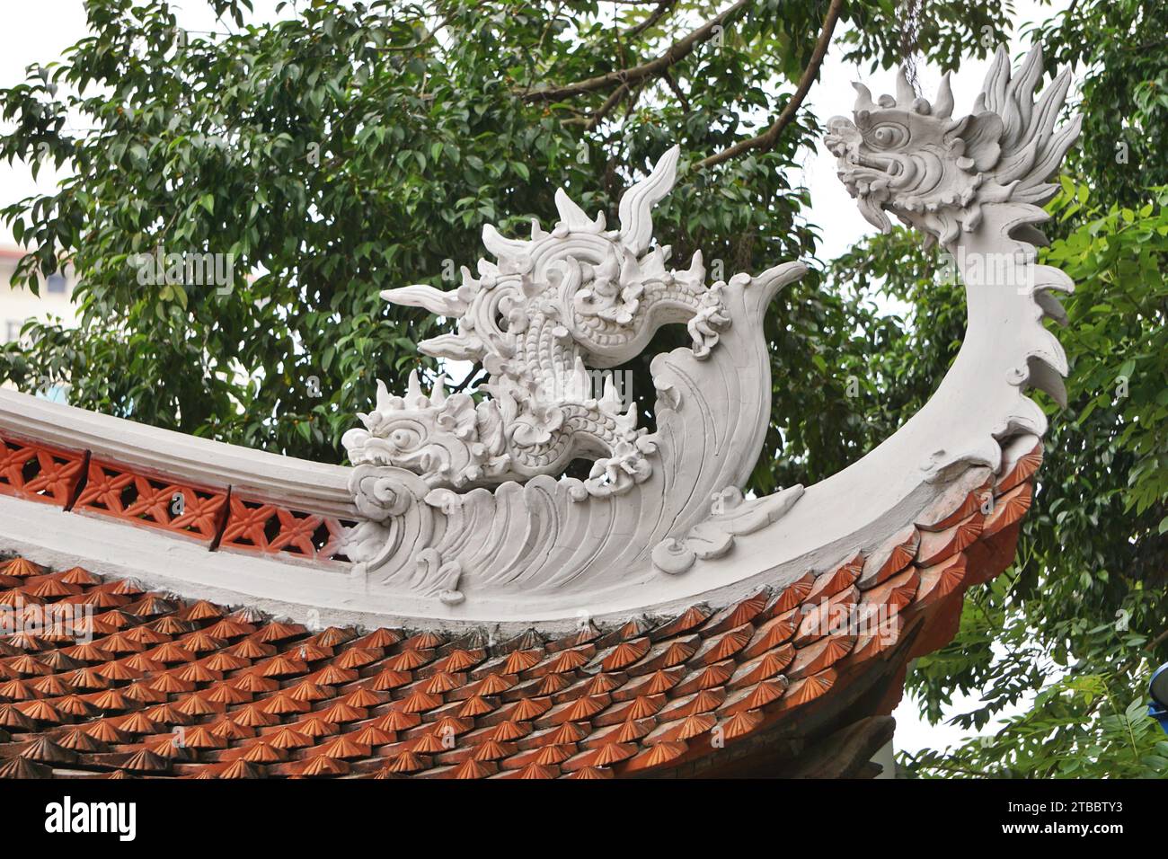 Two ornate sculpted white dragons stand guard on the corner of a ...