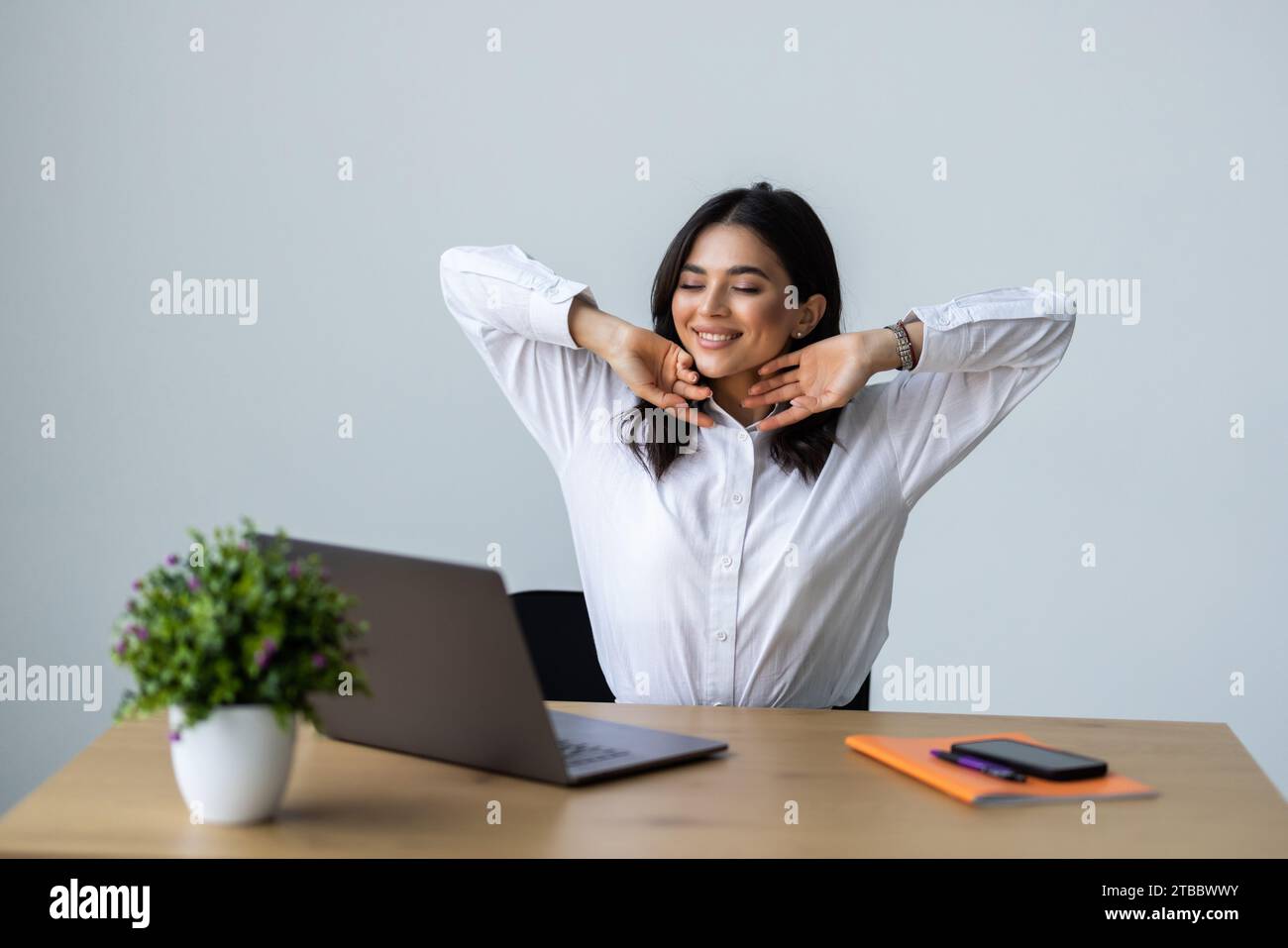 Happy female office worker leaning back on chair, relaxing after ...