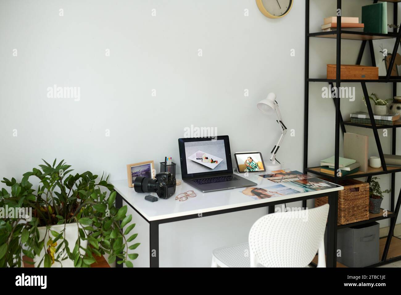 Laptop, digital camera and printed photos on desk of photographer Stock ...