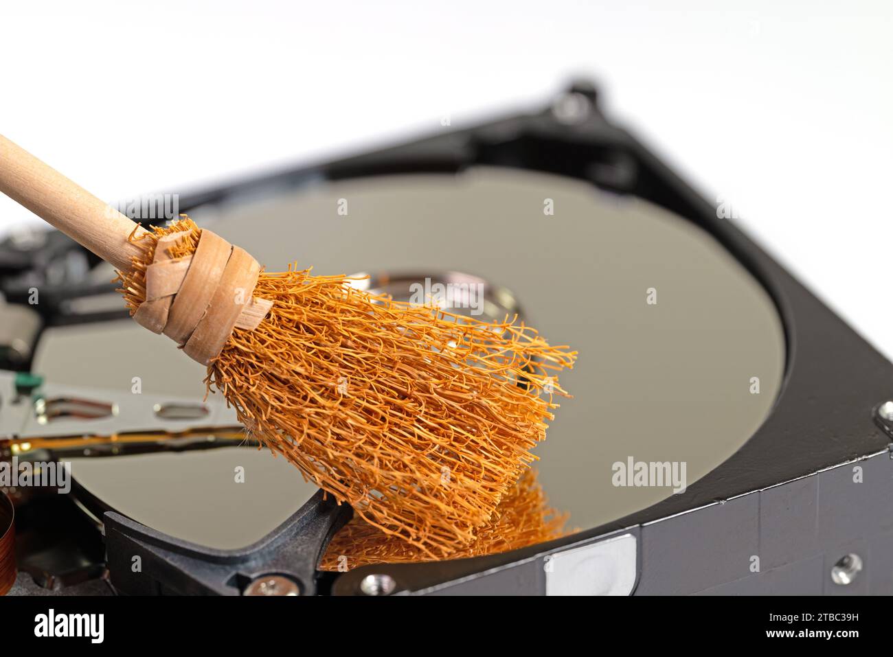 Broom on a hard drive, symbolic of disk cleanup Stock Photo - Alamy