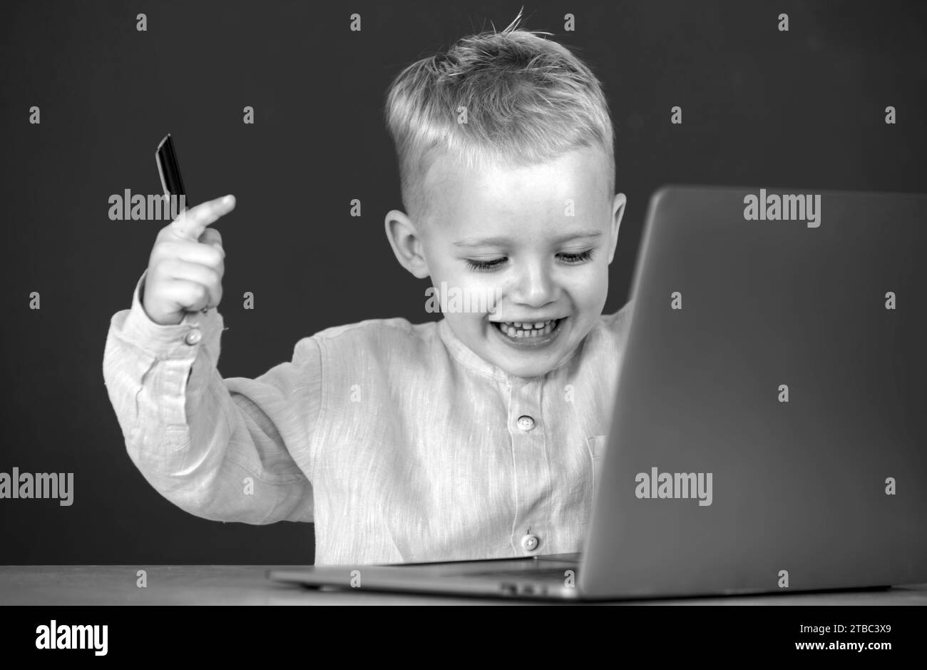 Little student boy using laptop computer in school class Stock Photo ...