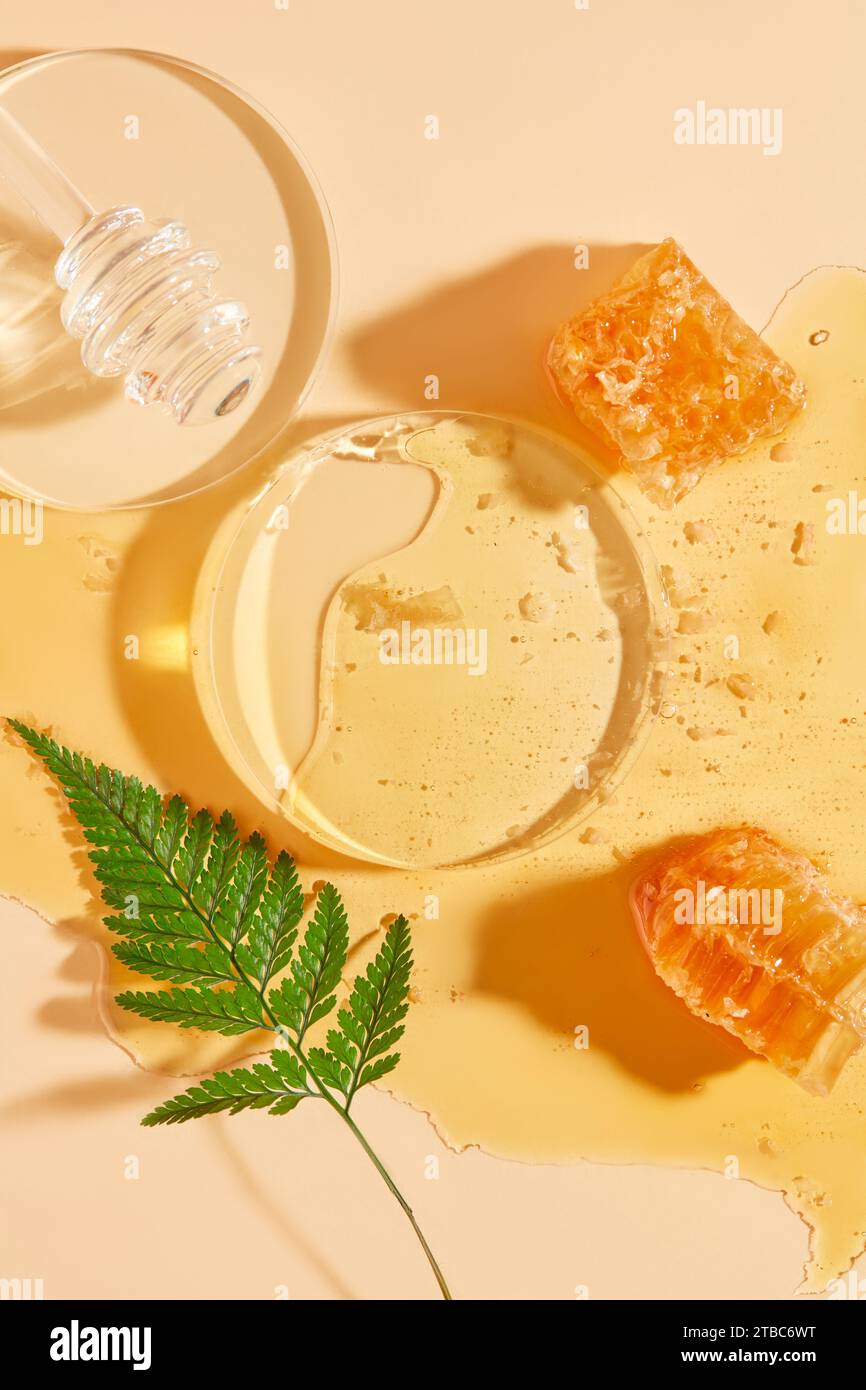 Glass podium arranged with a honey dripping and beeswax on honey. Stage ...