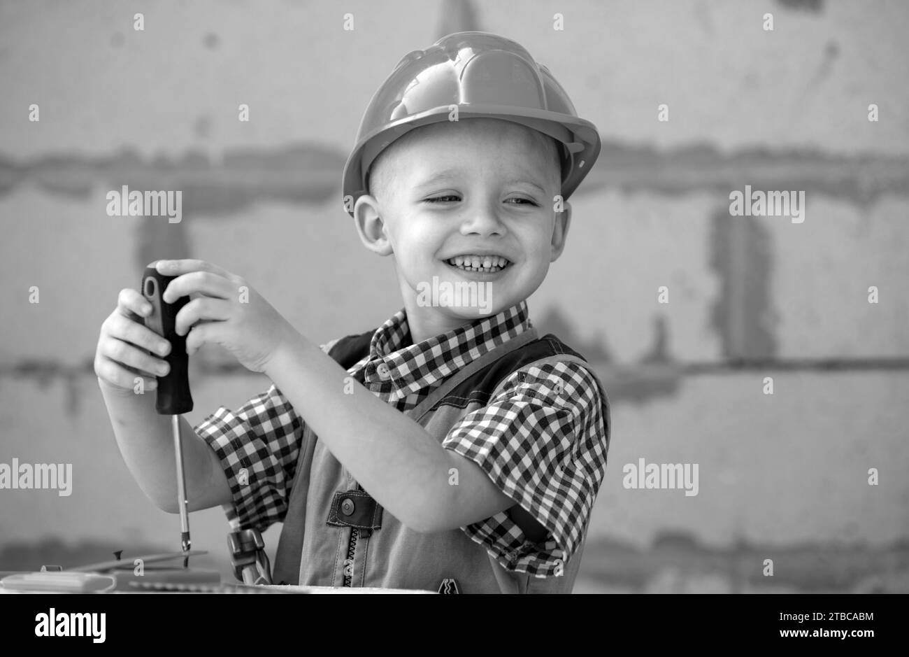 Little boy holding screwdriver. Happy smiling kid twists bolt with ...