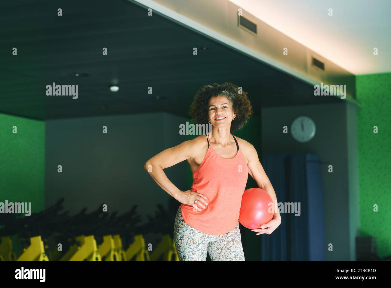 Indoor portrait of happy fit mature woman holding soft ball, active and ...