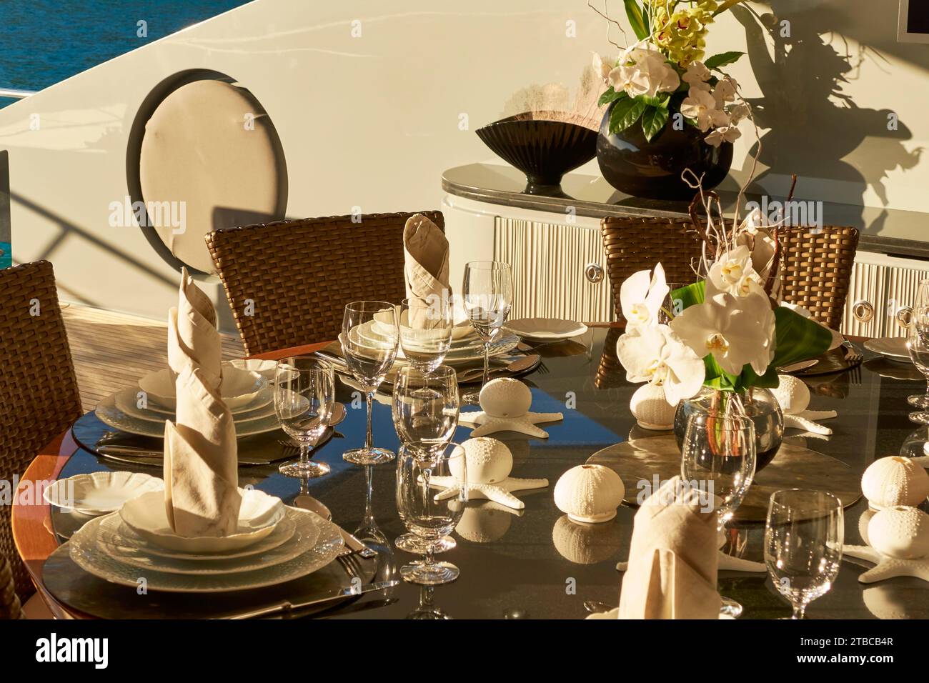 Luxury yacht charter table setting with flowers,wine glasses and marine ...