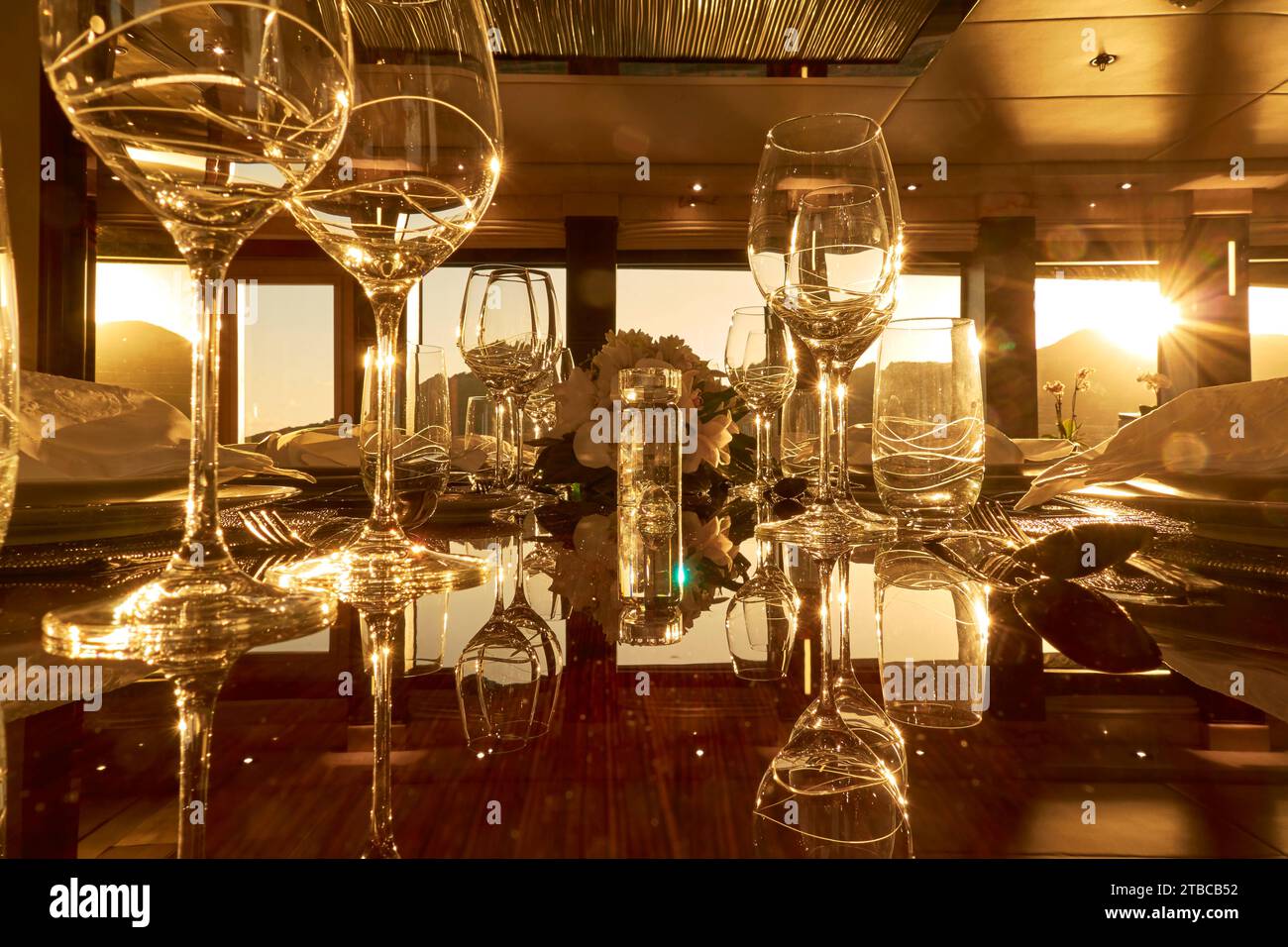 Luxury yacht charter table setting with flowers,wine glasses and marine ...