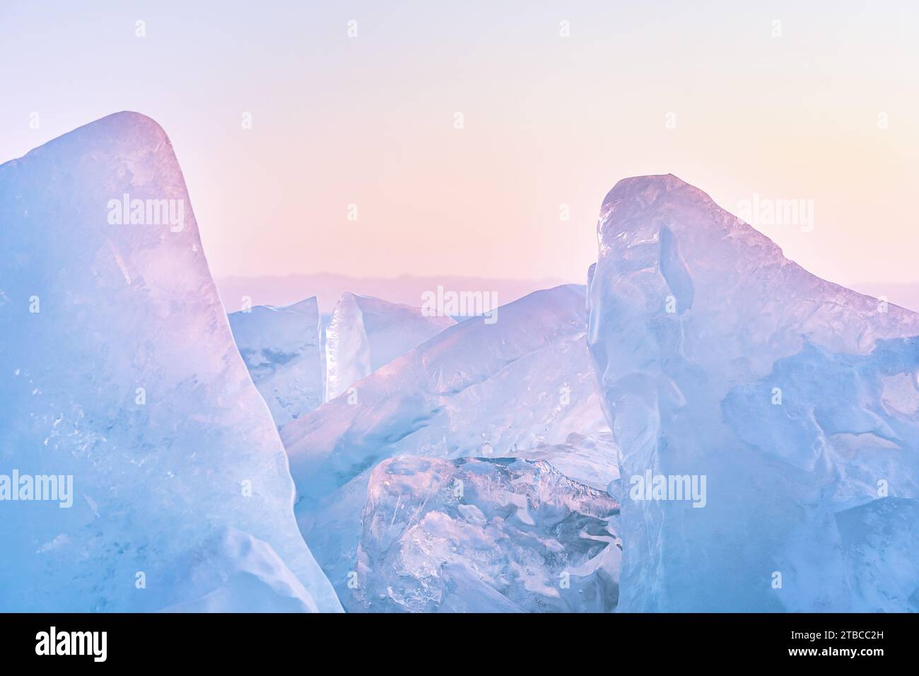 Winter landscape with ice hummocks glittering in the sun and mountains ...