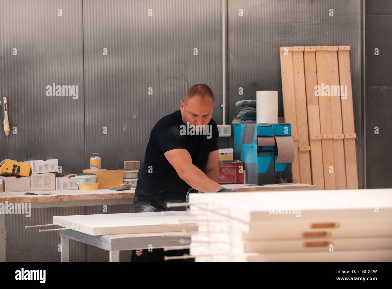 A skilled craftsman in the woodworking industry meticulously operates a ...