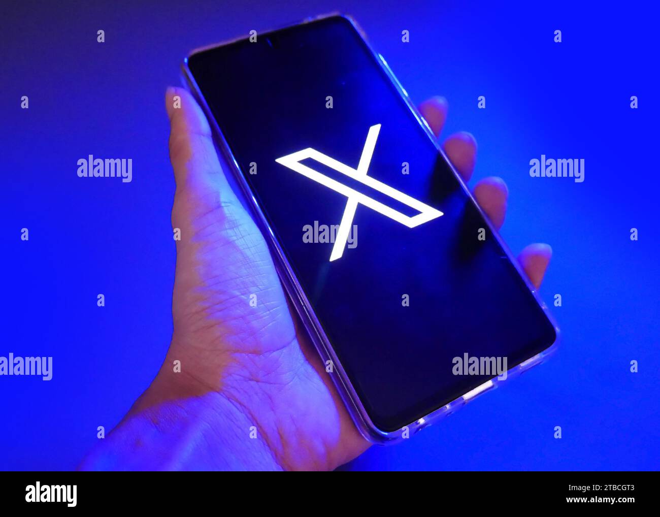 X twitter new logo on smart phone screen with neon light Stock Photo ...