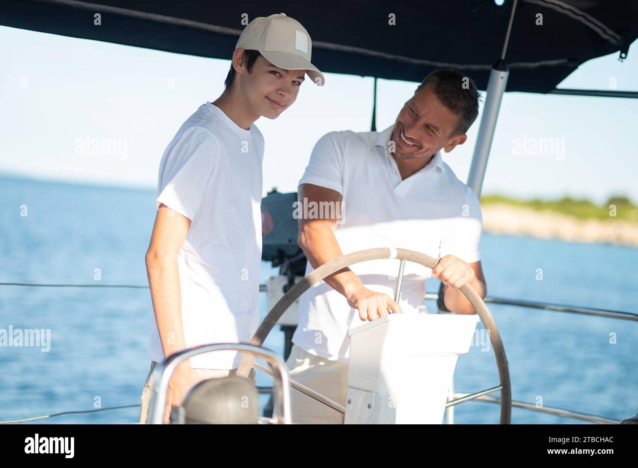 Dad showing his son how to manage the boat Stock Photo - Alamy