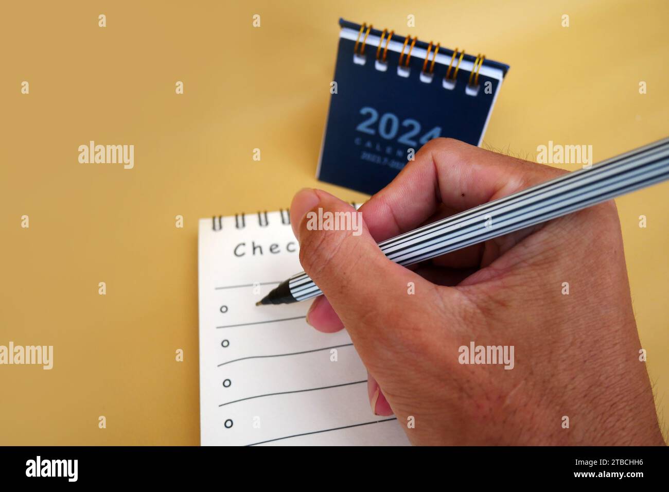 Top view. Checklist book with 2024 calendar and green plant. New Year ...