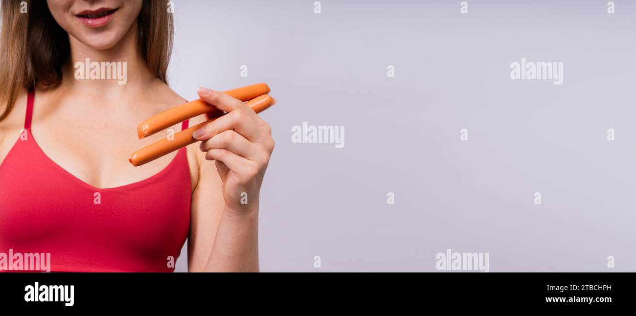 Woman opened her mouth and wants to bite off the sausage, close-up ...