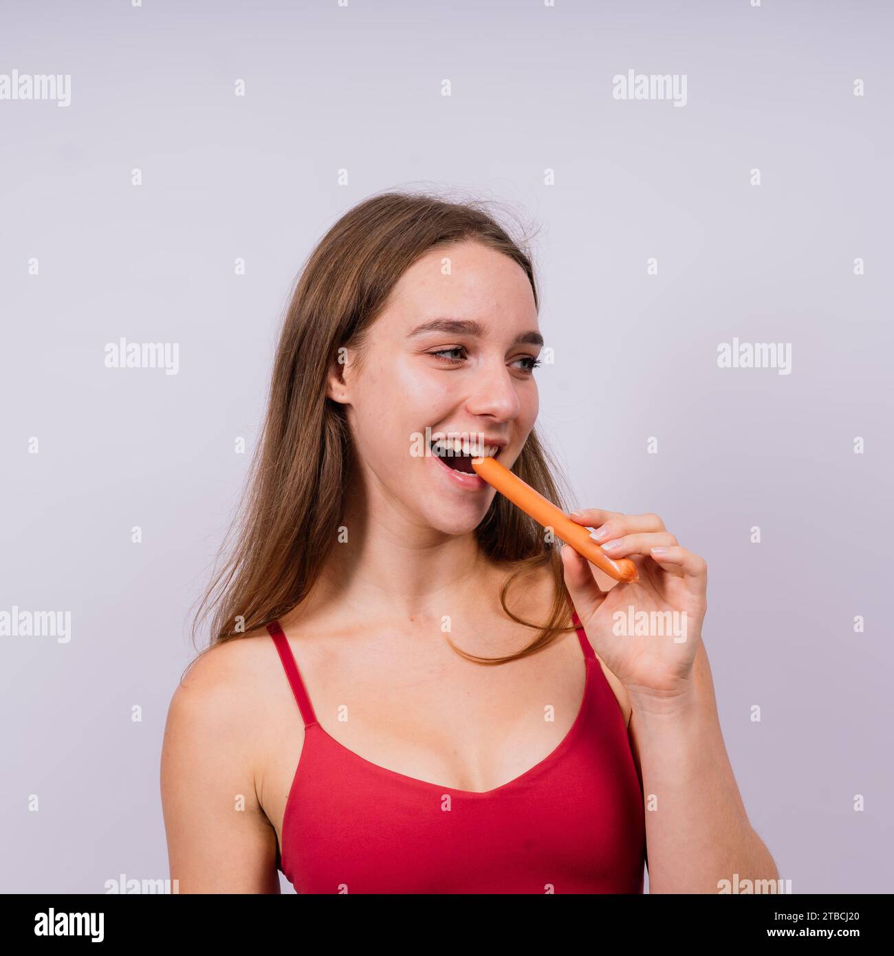 Woman opened her mouth and wants to bite off the sausage, close-up ...