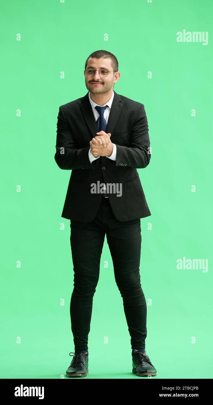 full-length portrait of a young man. standing isolated on green ...