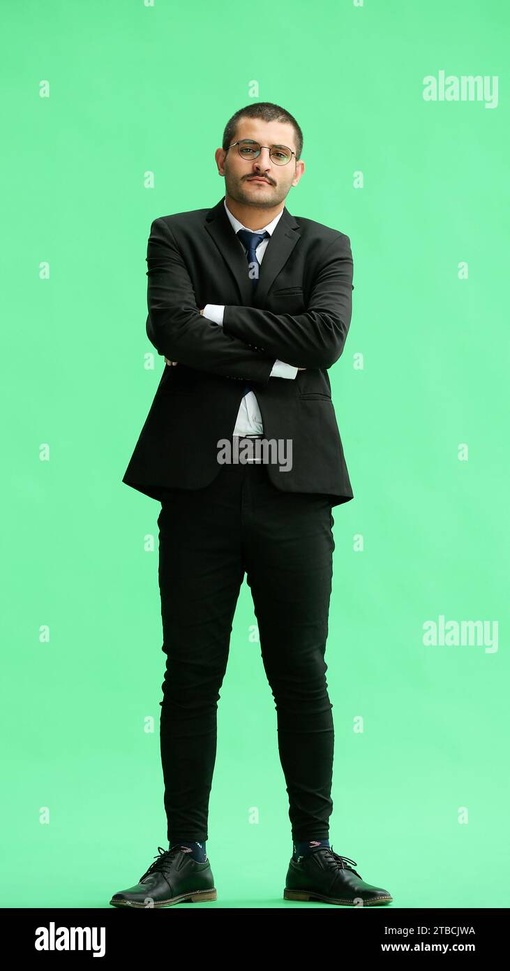 full-length portrait of a young man. standing isolated on green ...