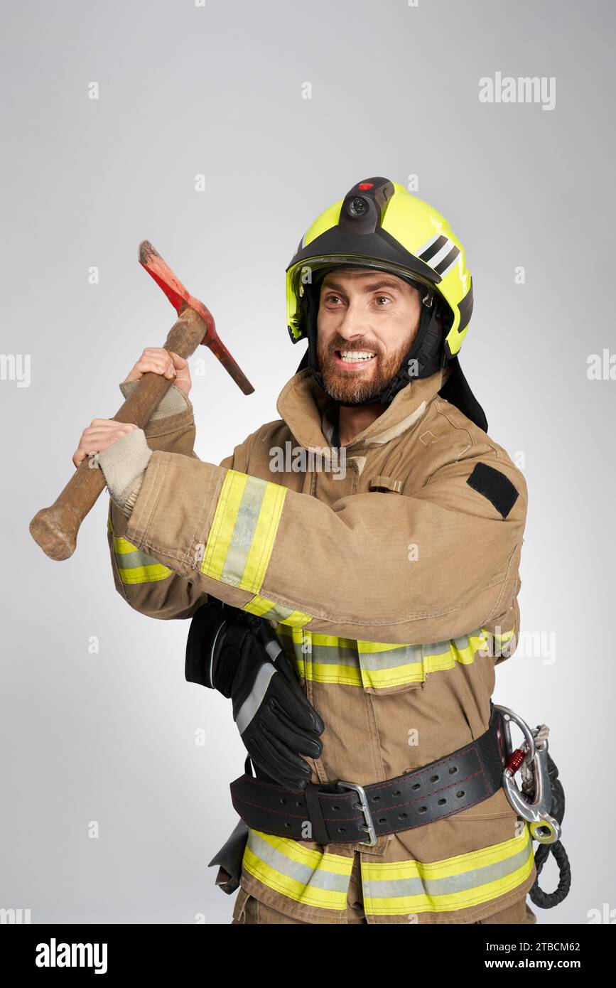 Handsome, brave firefighter battling fire, while using shabby ax ...