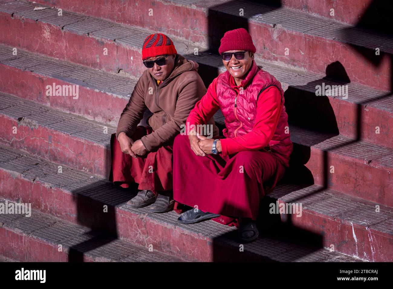Two monks sitting on the stairs to Korzok monastery, Korzok, Ladakh ...