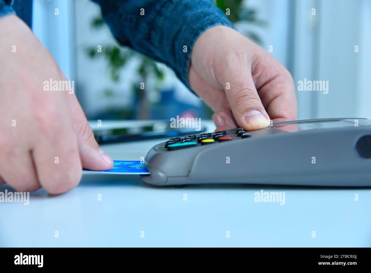 Hand makes payment by blue credit card. Electronic money and shopping ...